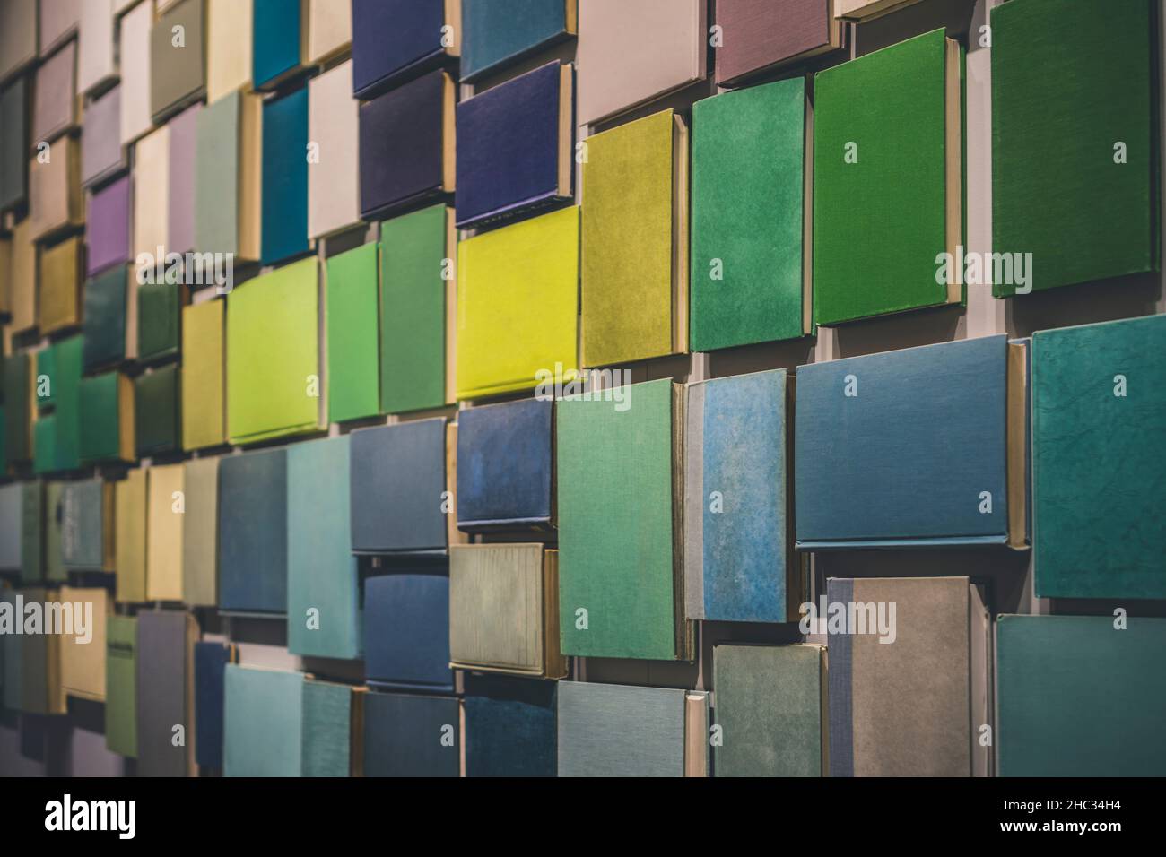 Many books creating feeling of wallpaper attached to a wall. Colorful ...