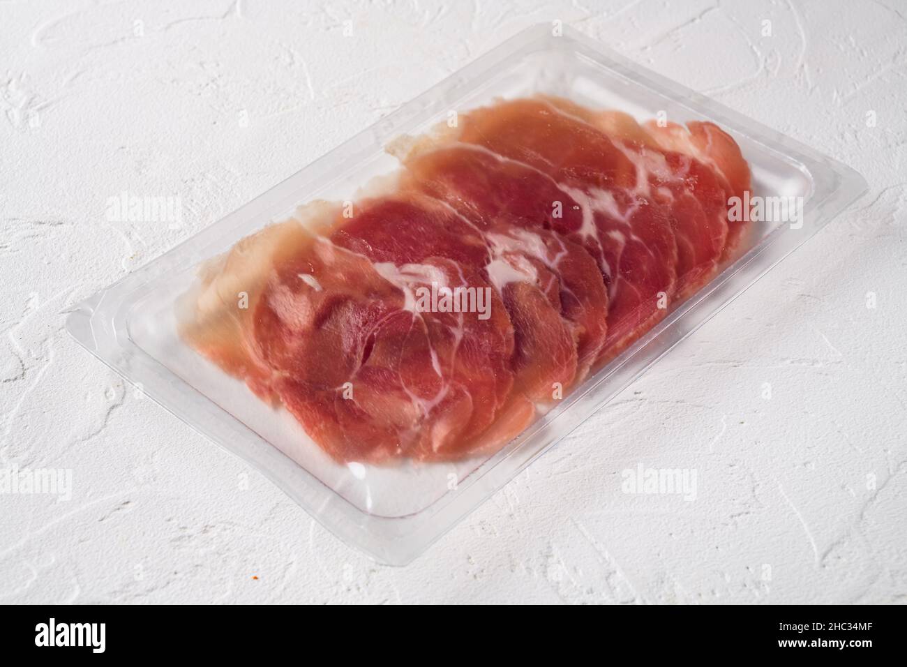 Cured ham jamon vacuum plastic pack set, on white stone table ...