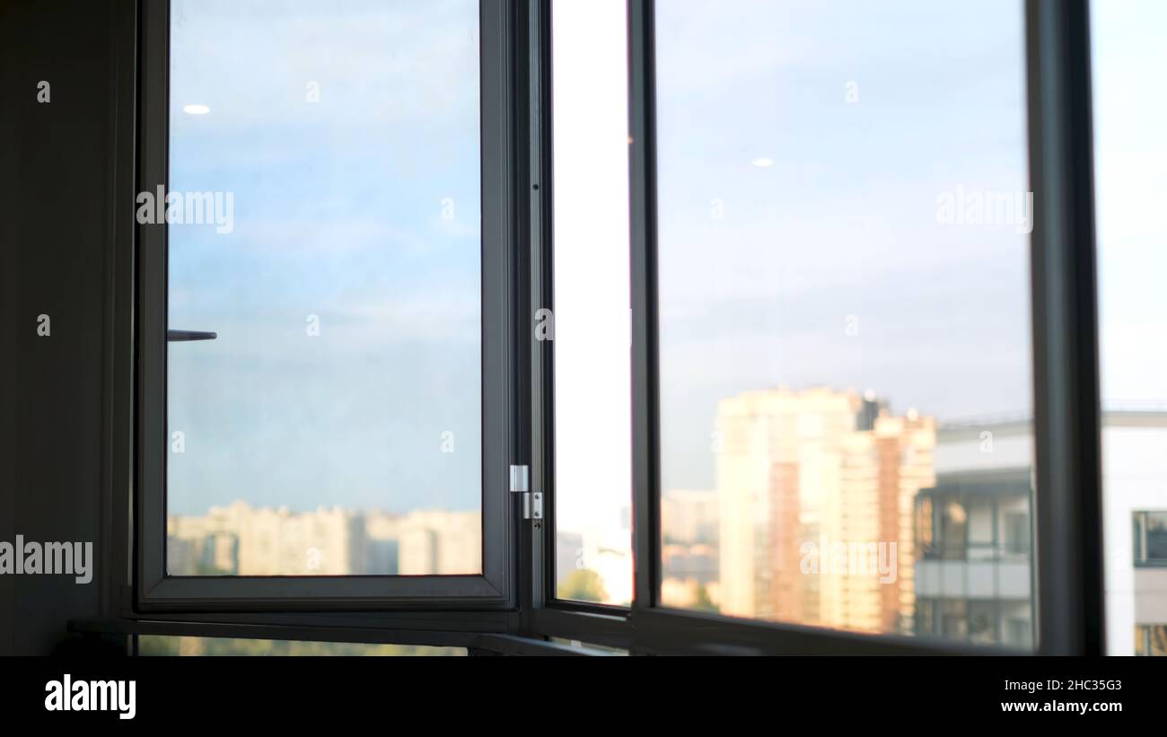 Close up of opened window with the blue cloudy sky and high rise ...