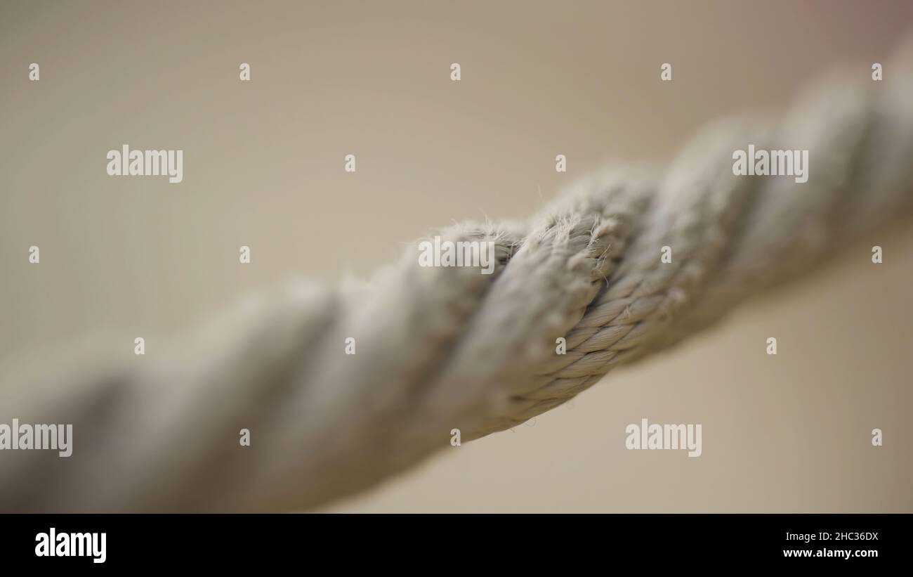 Extreme close up of a rope on blurred beige background. Macro view of a ...