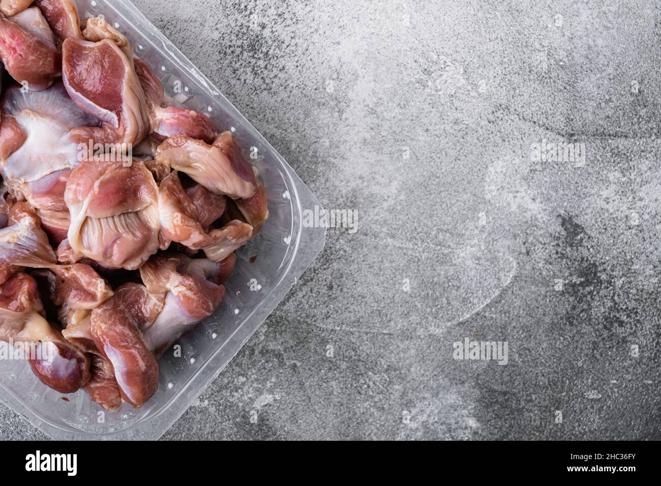 Raw chicken gizzards market plastic pack set, on gray stone table ...