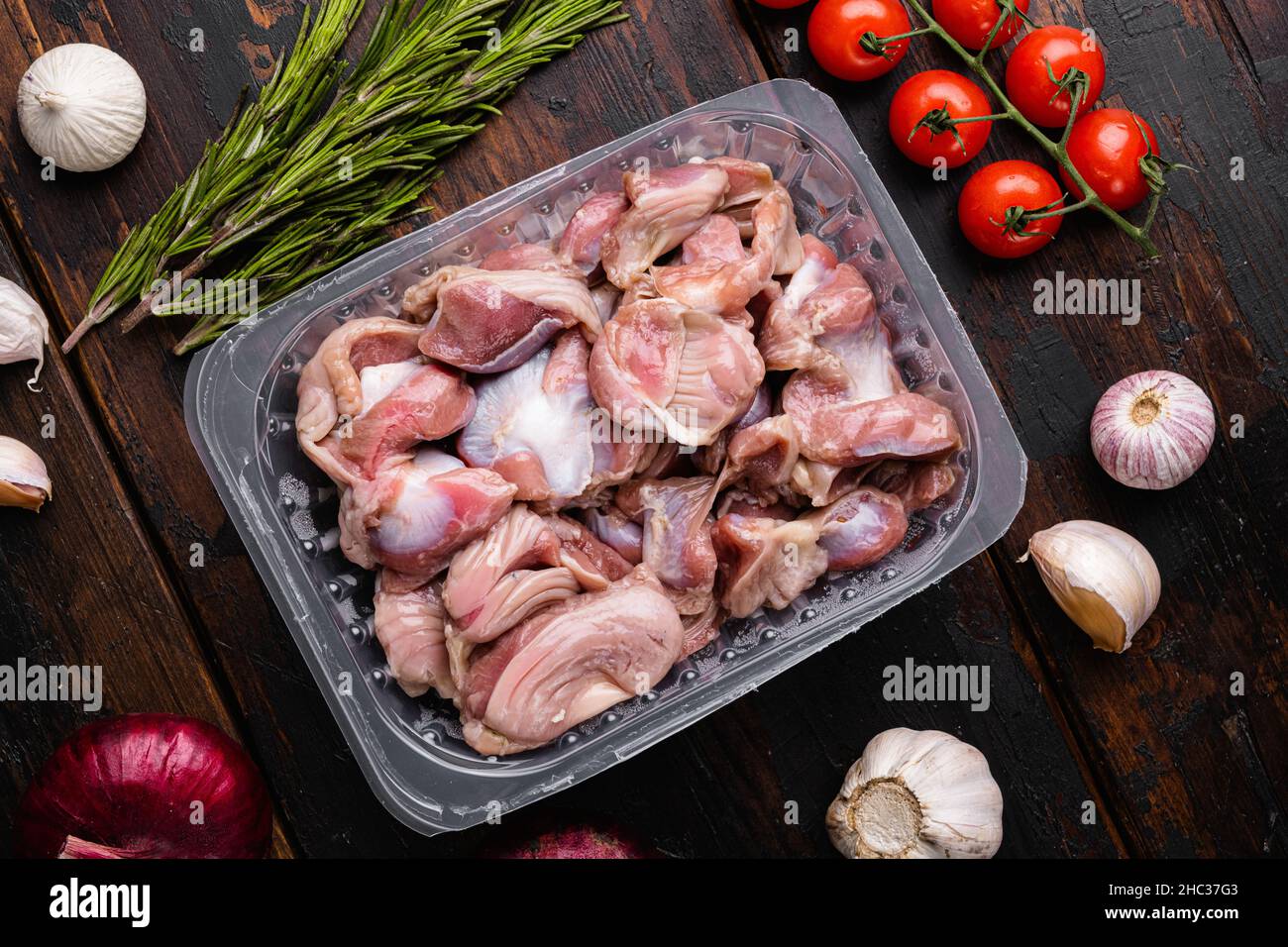 Raw chicken gizzards market plastic pack set, on old dark wooden table ...