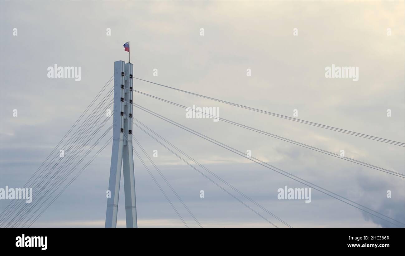 Russian Federation flag fluttering in the wind on the top of the bridge ...