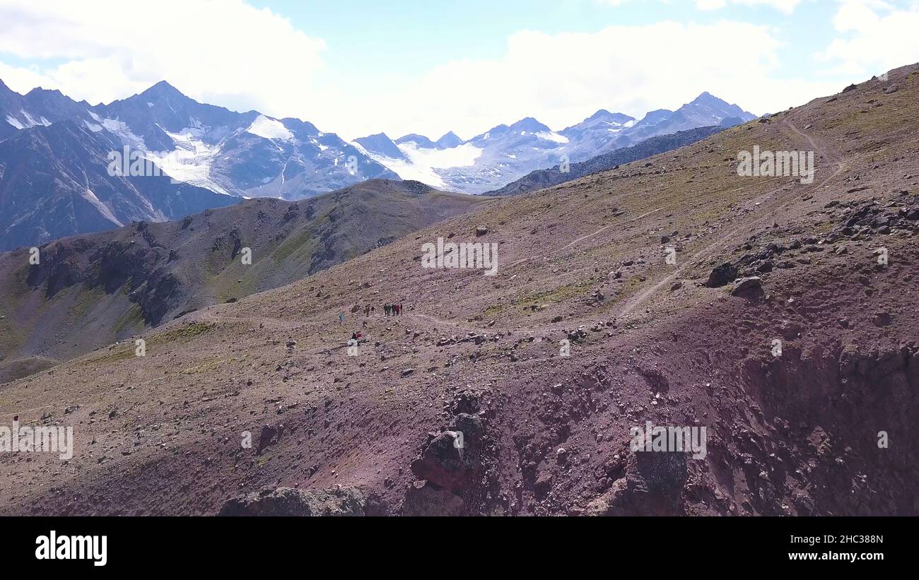 Aerial view of the mountain slopes and hiking people. Group of tourists ...