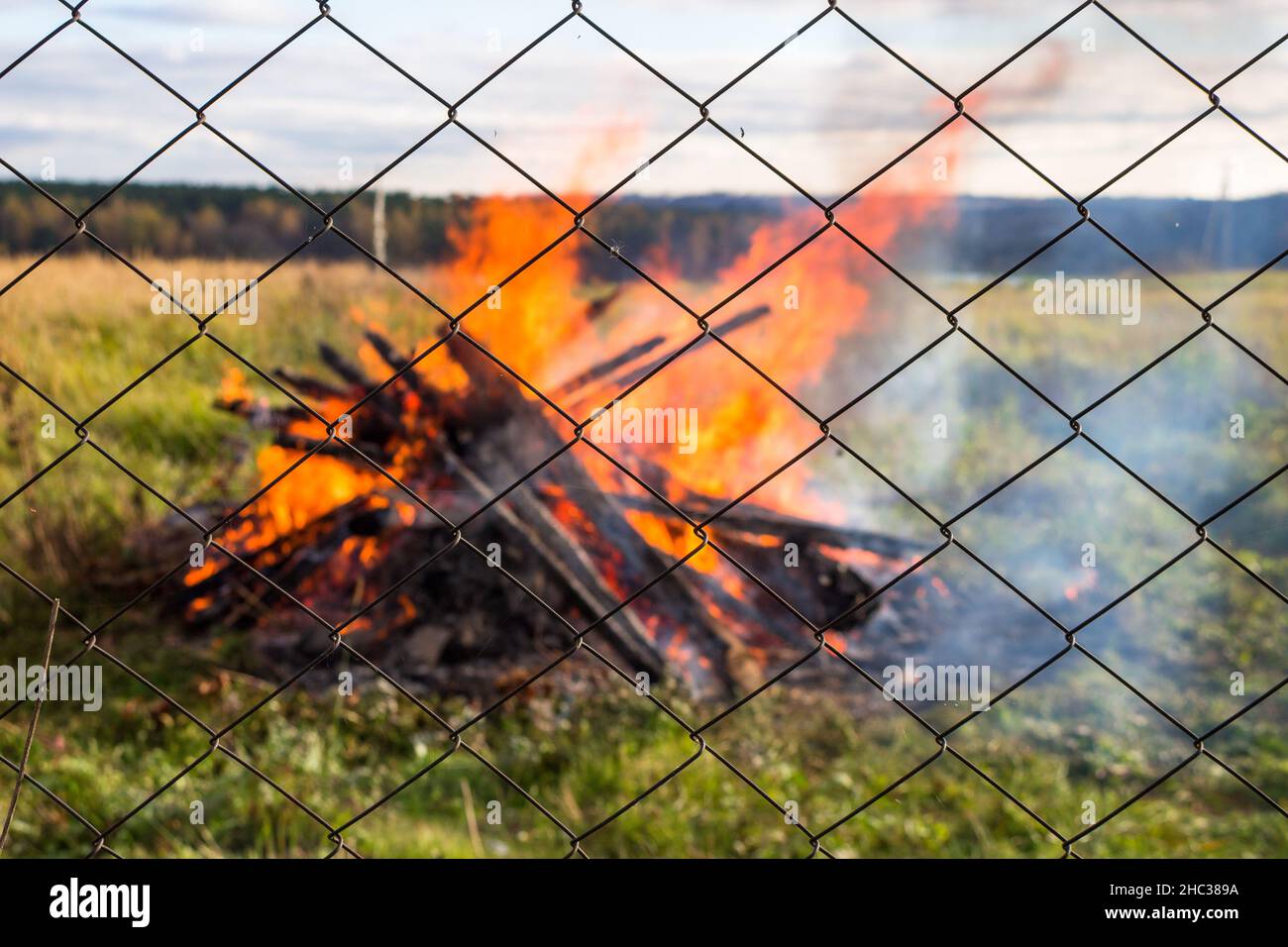 Background with a mesh fence and a large bonfire in the background ...
