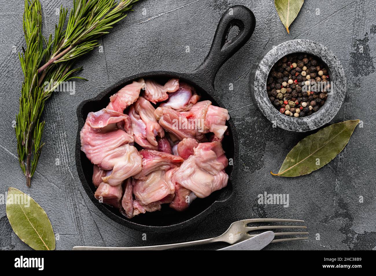 Raw uncooked chicken gizzards, stomach set, on gray stone table ...