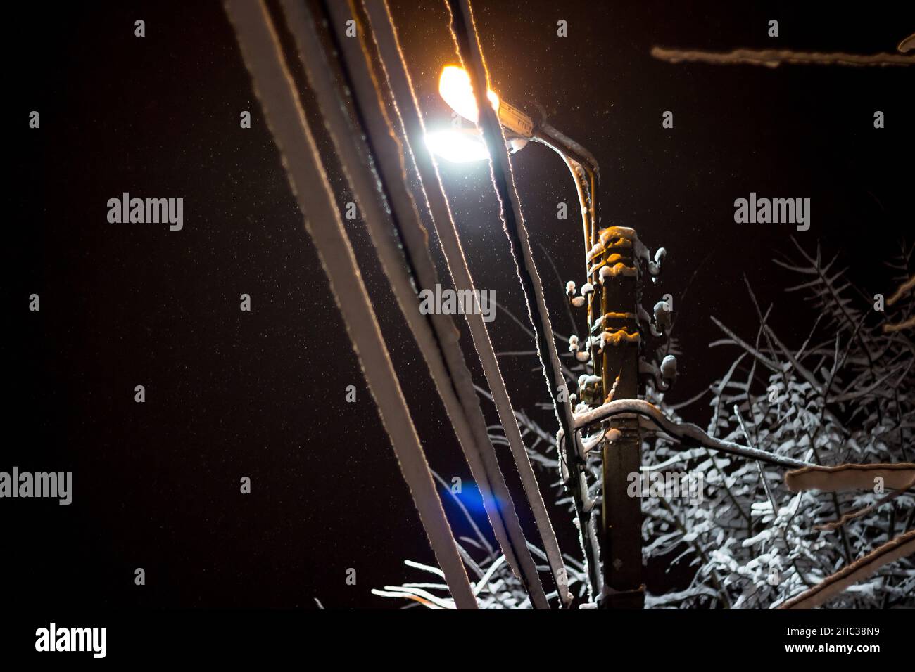Snowfall and snow on wires under a street lamp at night Stock Photo - Alamy