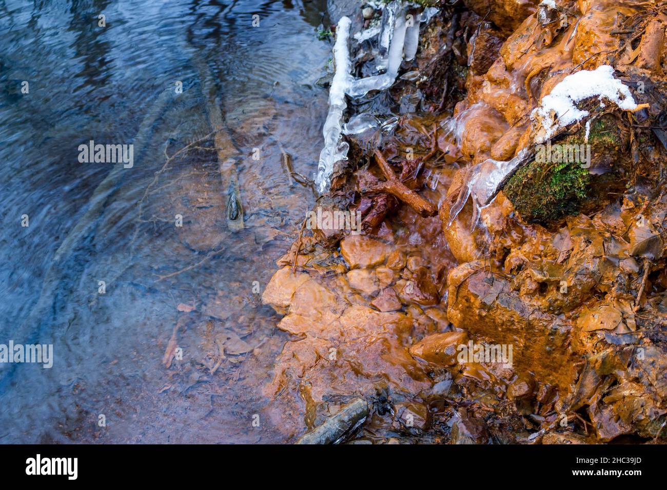 Output of mineral ferruginous springs, orange color of iron ocher ...