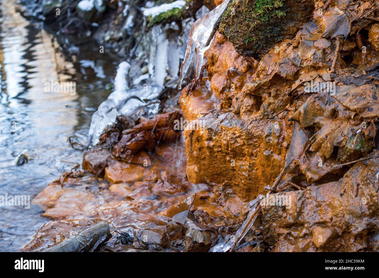 Output of mineral ferruginous springs, orange color of iron ocher ...