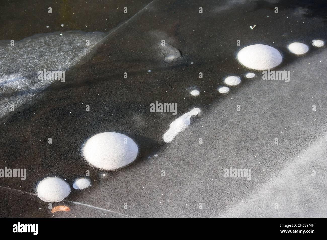 Frozen air bubbles on ice Stock Photo - Alamy