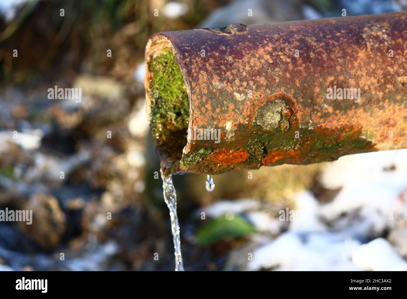Metal pipe with flowing spring water Stock Photo - Alamy