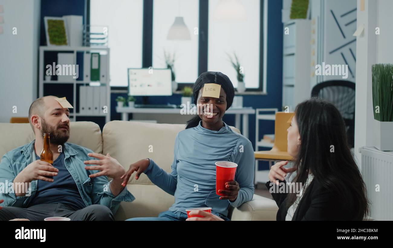 Happy colleagues playing guessing game for fun activity after work ...