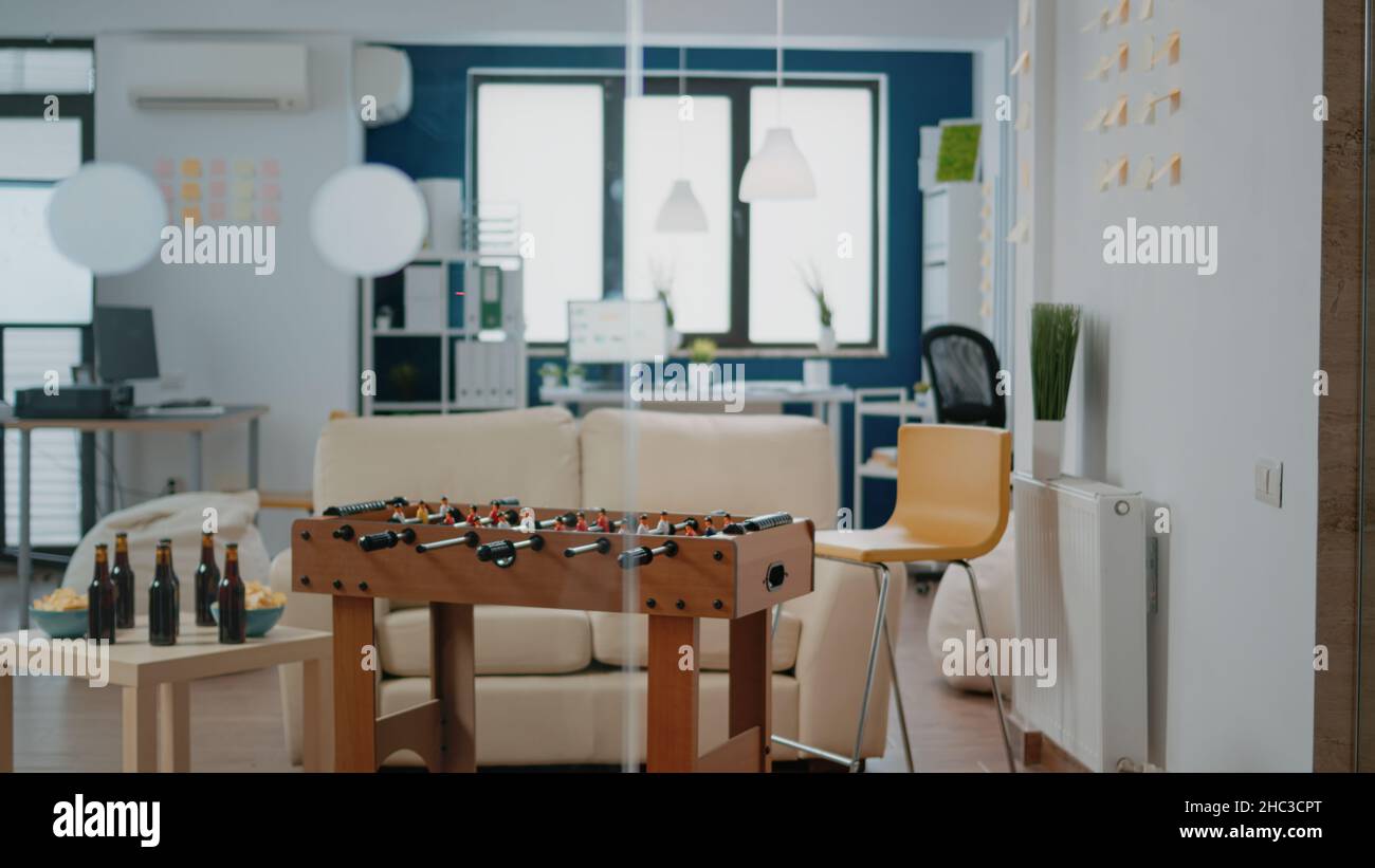 Nobody in workplace with fun activity for meeting after work. Empty office with foosball game ...