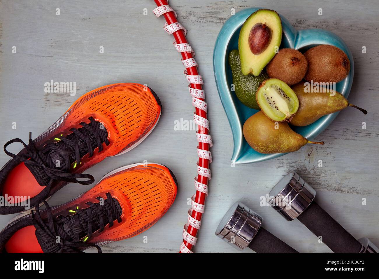 Orange sports sneakers, gymnastic ring wrapped in a measuring tape with ...