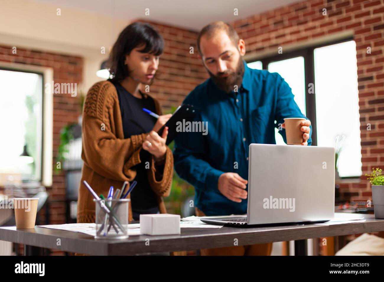 Colleagues looking at company strategy using laptop computer analyzing ...