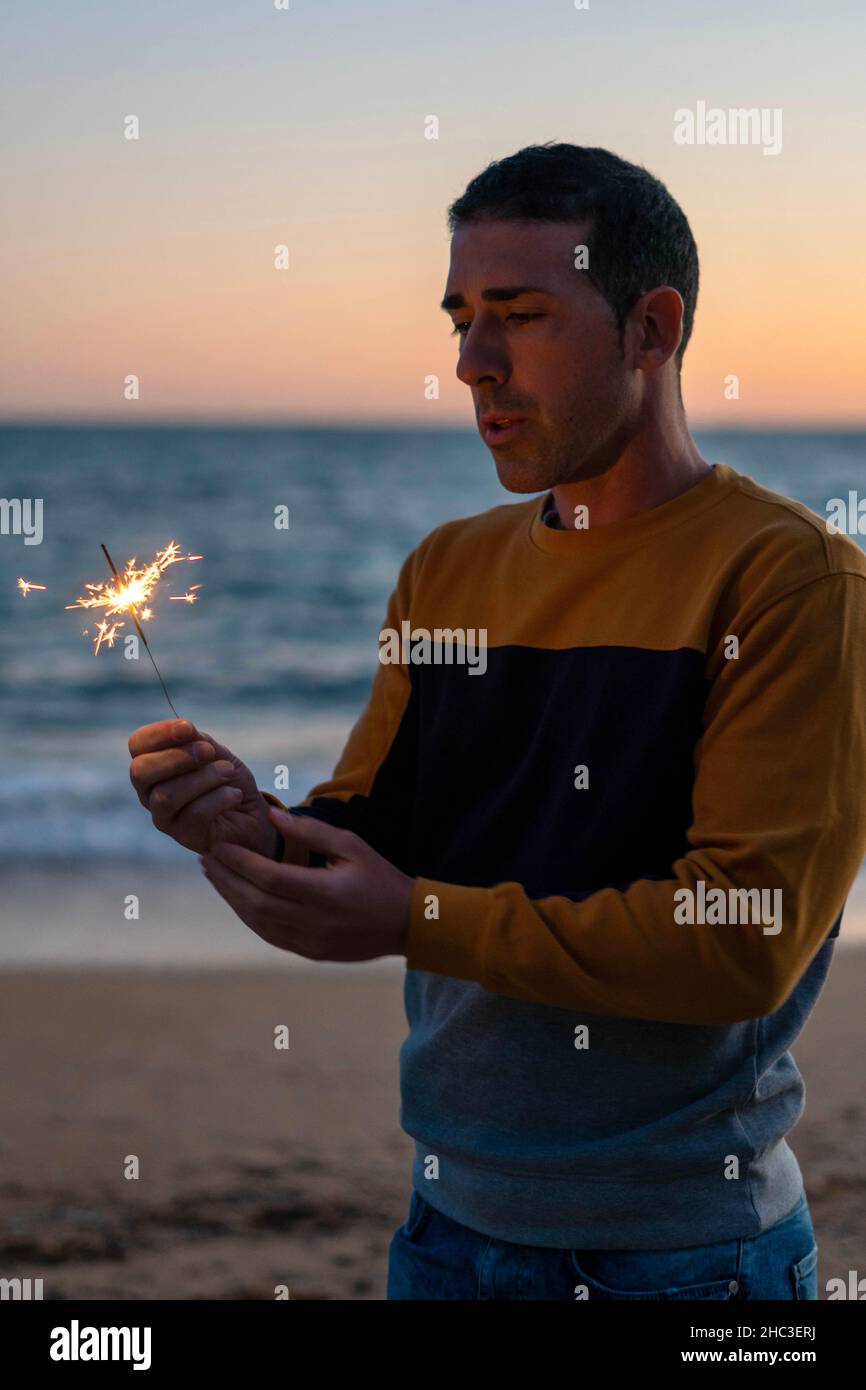 A man making a wish trough a sparkler Stock Photo - Alamy