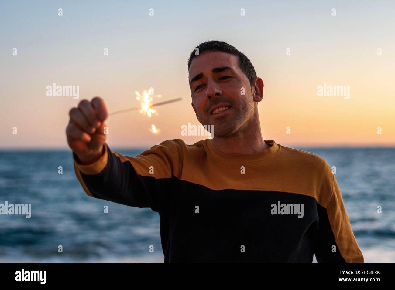 A man making a wish trough a sparkler Stock Photo - Alamy