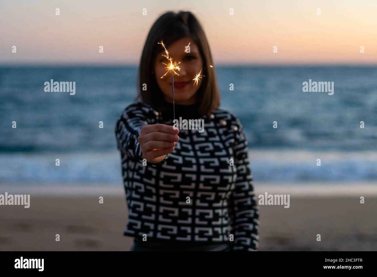 Young woman making a wish with her magic sparkler in the sand Stock ...