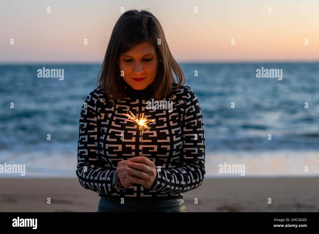 Young woman making a wish with her magic sparkler in the sand Stock ...