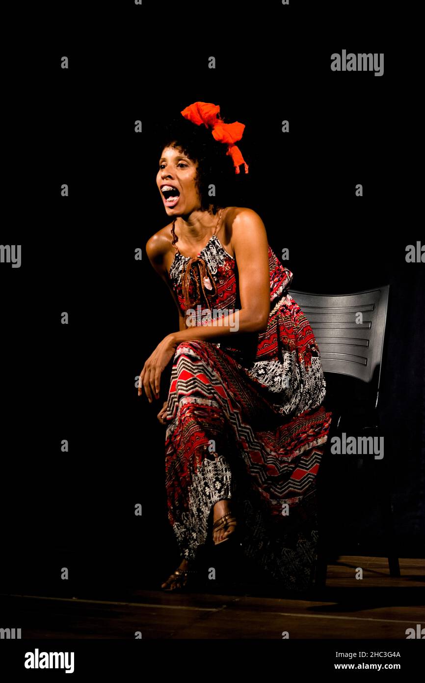 Actress on stage represents a dramatic character. She is sitting in a ...