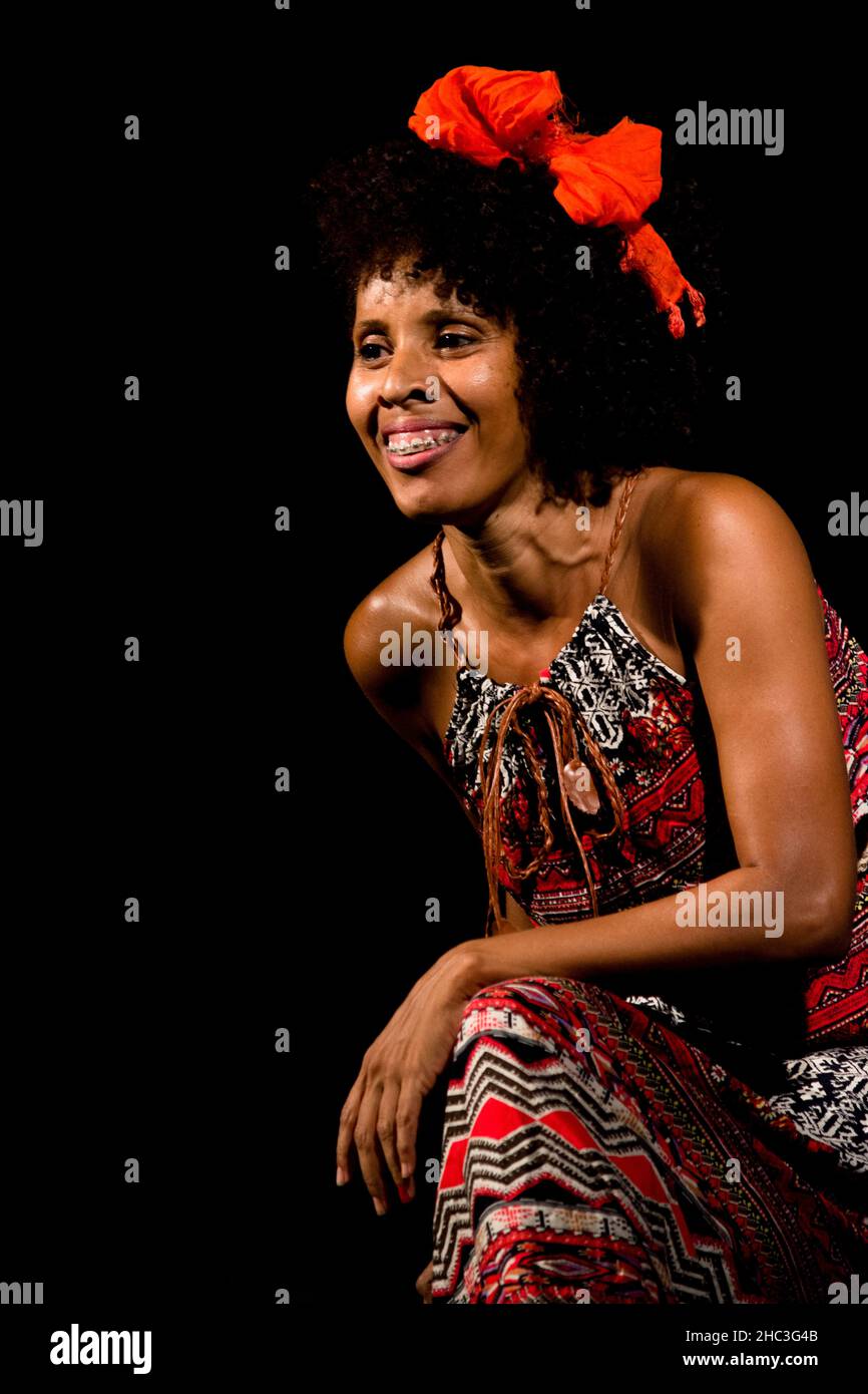 Actress on stage represents a dramatic character. She is sitting in a ...