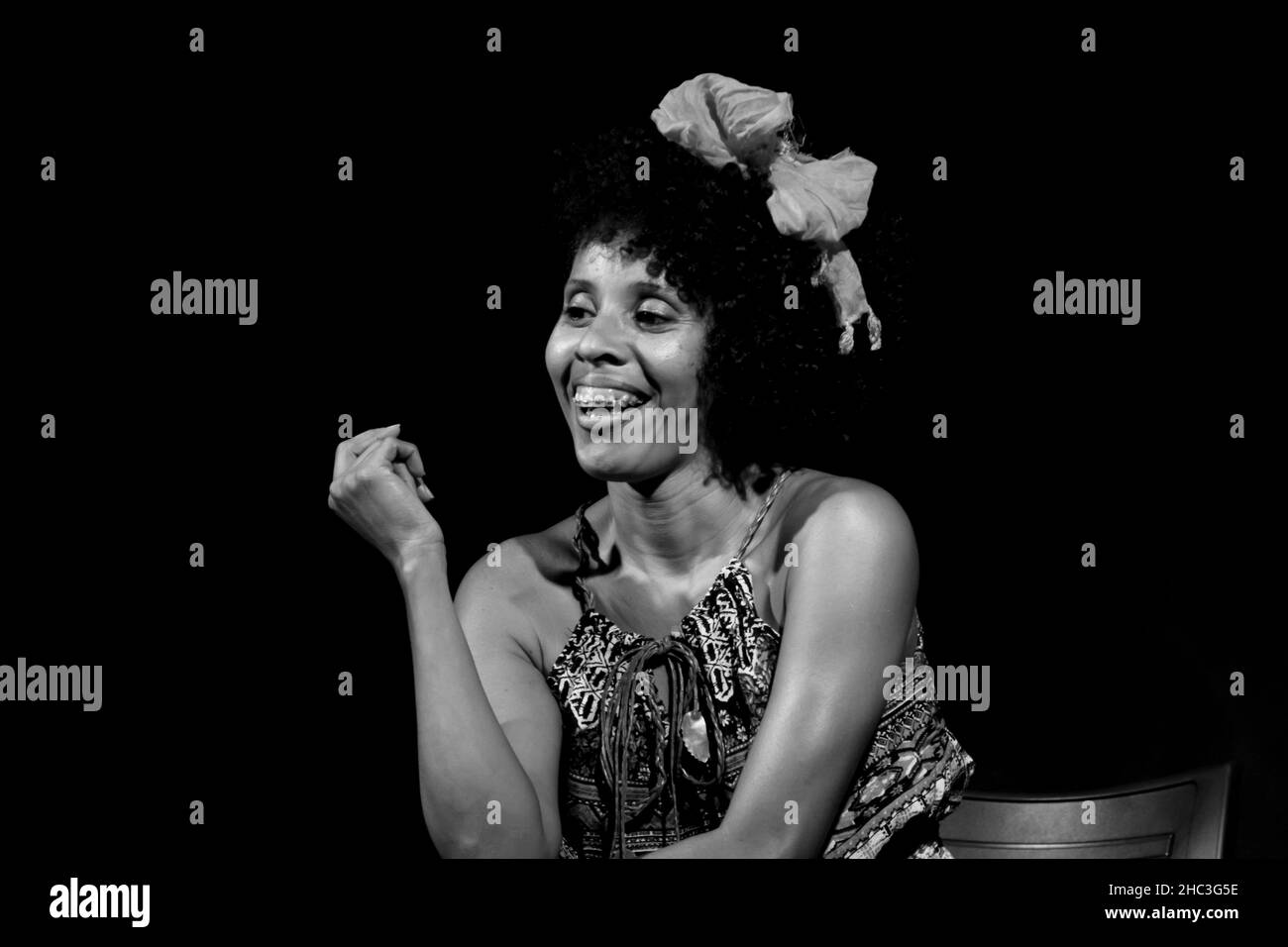 Actress on stage represents a dramatic character. She is sitting in a ...