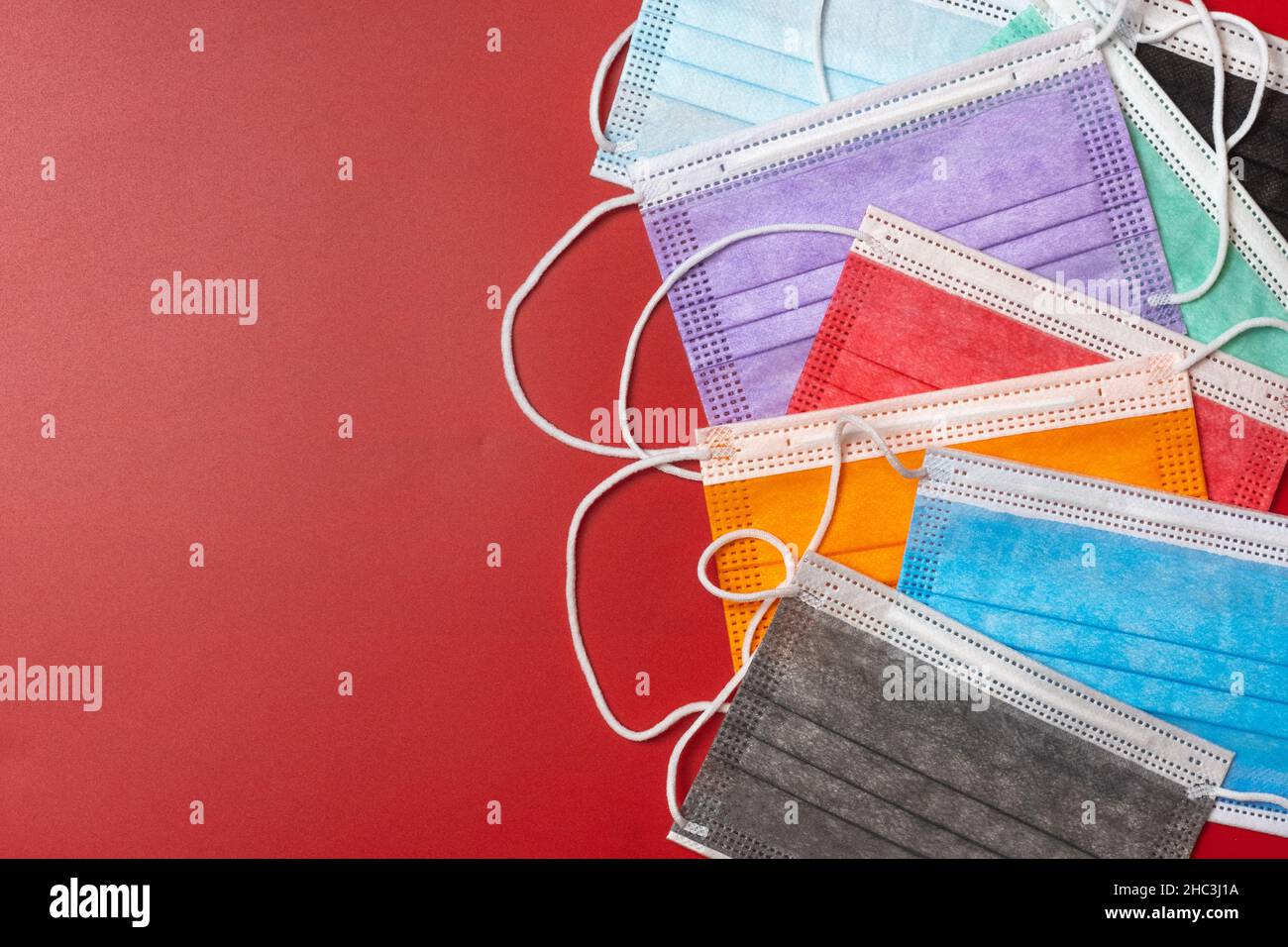 Top view of a table with colorful face masks piled and space to copy ...