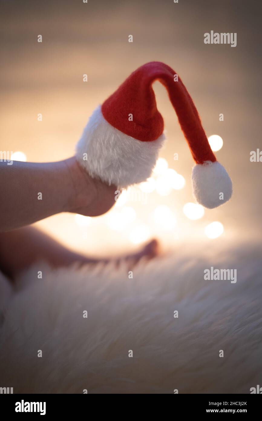 Feet of a newborn with a Santa hat on a fluffy blanket with Christmas ...
