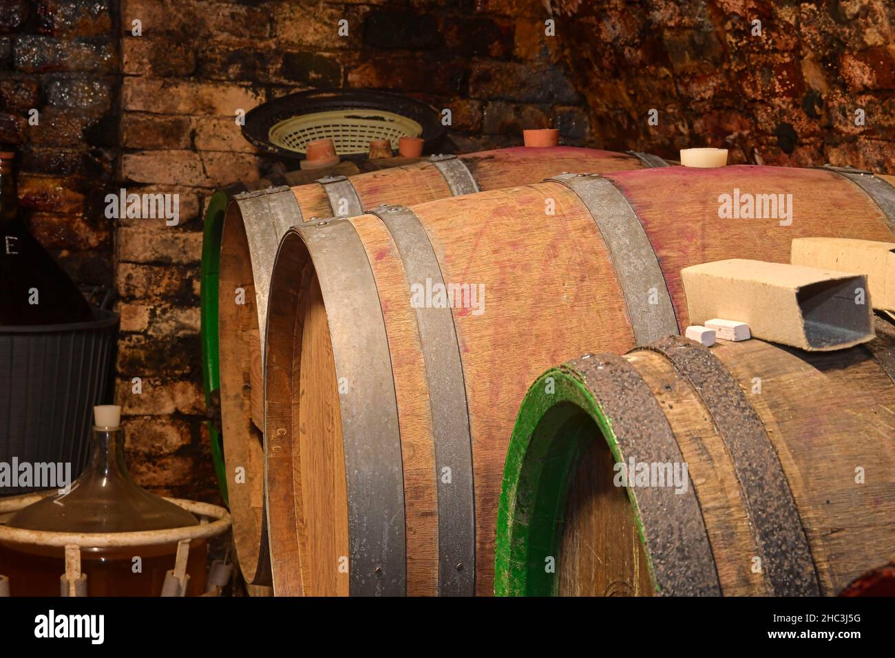 Old wine cellar with demijohns and wooden barrels. Making wine ...