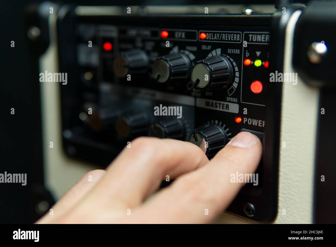 Close up of a man's hand switching on an amplifier Stock Photo - Alamy