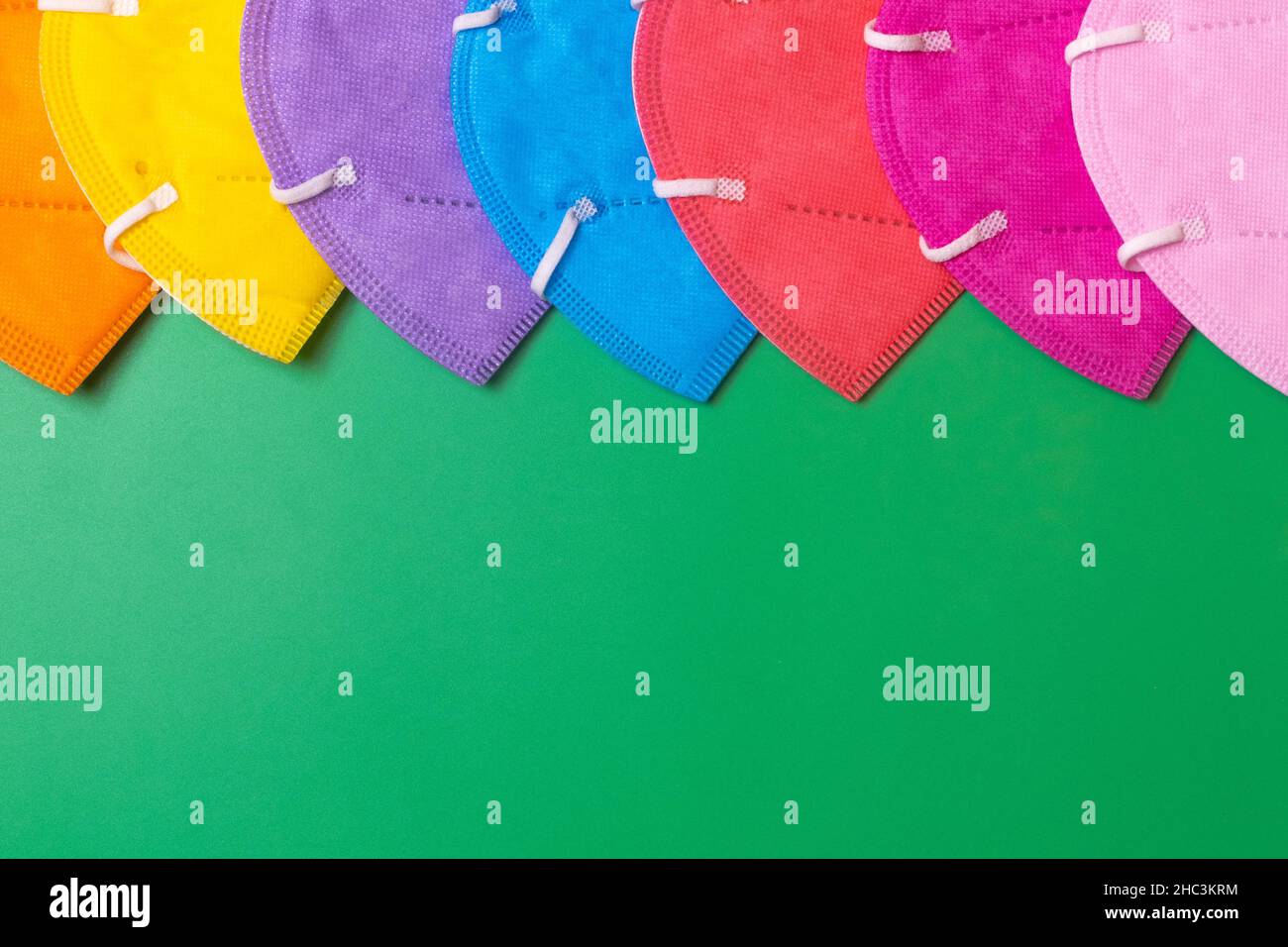 Top view of a table with colorful face masks piled and space to copy ...