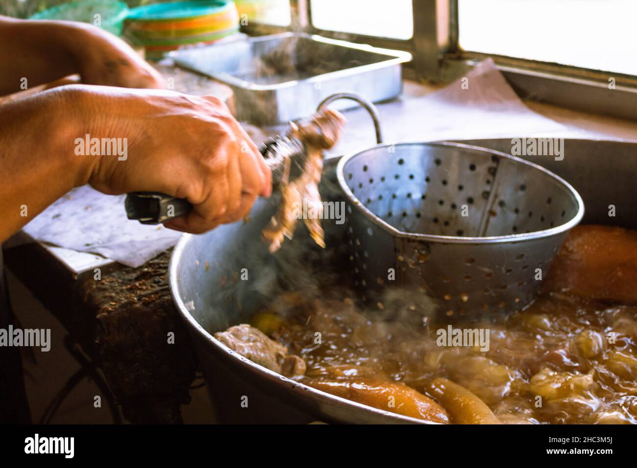 photograph of the hands of an adult man taking the meat to prepare ...