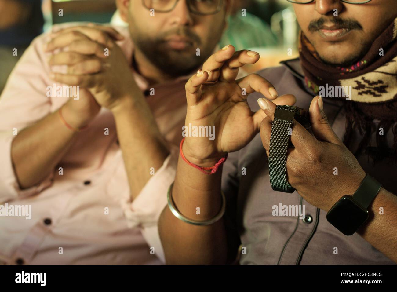A person showing the smart watch function to another person. The second ...
