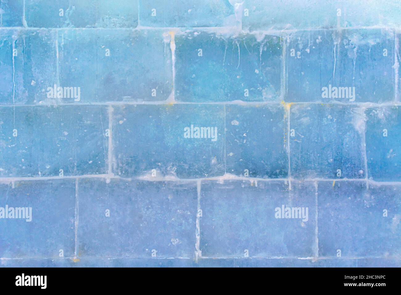 The textured surface of a translucent large ice wall made of large ...