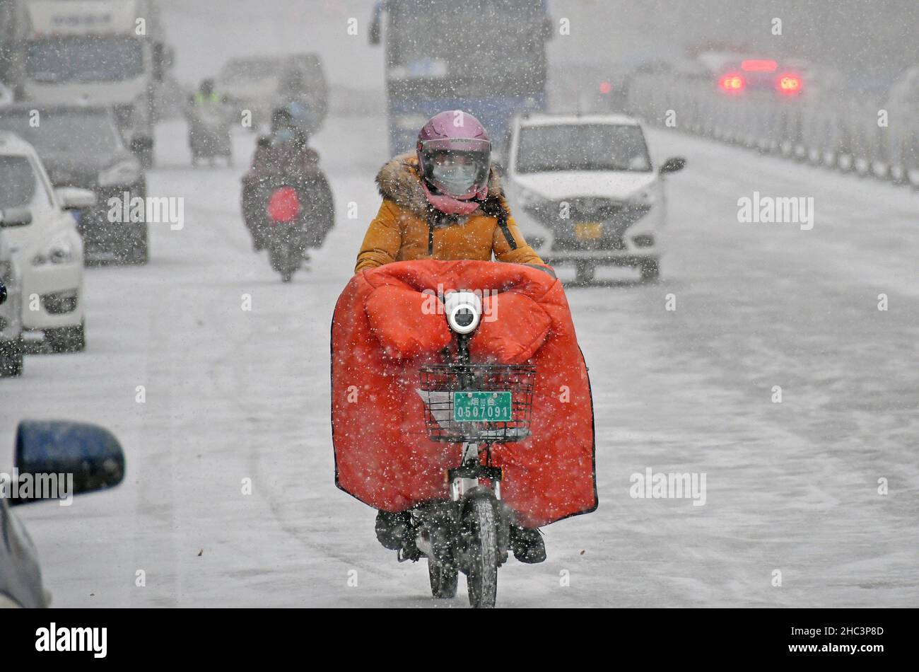 YANTAI, CHINA - DECEMBER 24, 2021 - Cyclists wear thick clothing to ...