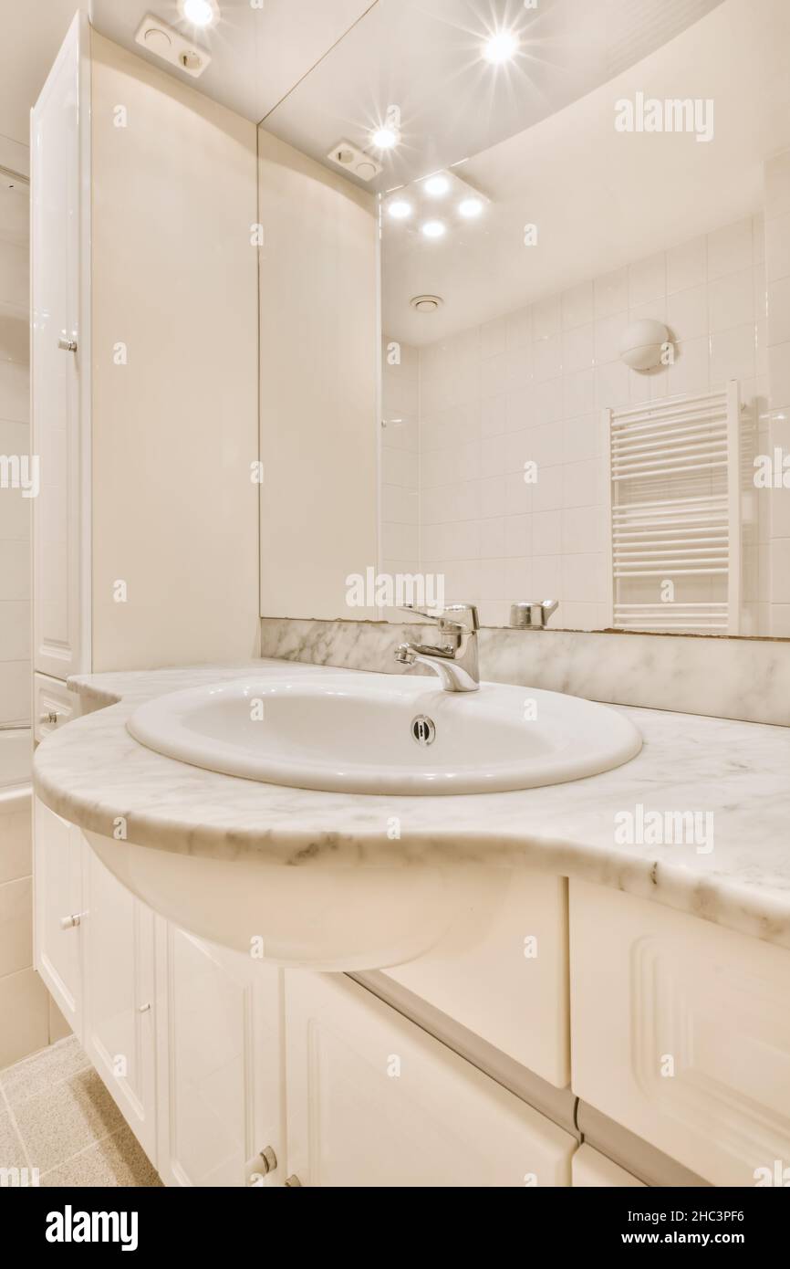 Delightful bathroom with huge mirror and round sink Stock Photo - Alamy