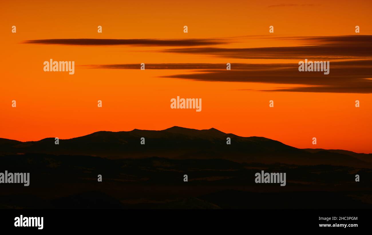 A colorful winter sky over the silhouettes of the mountains. The ...