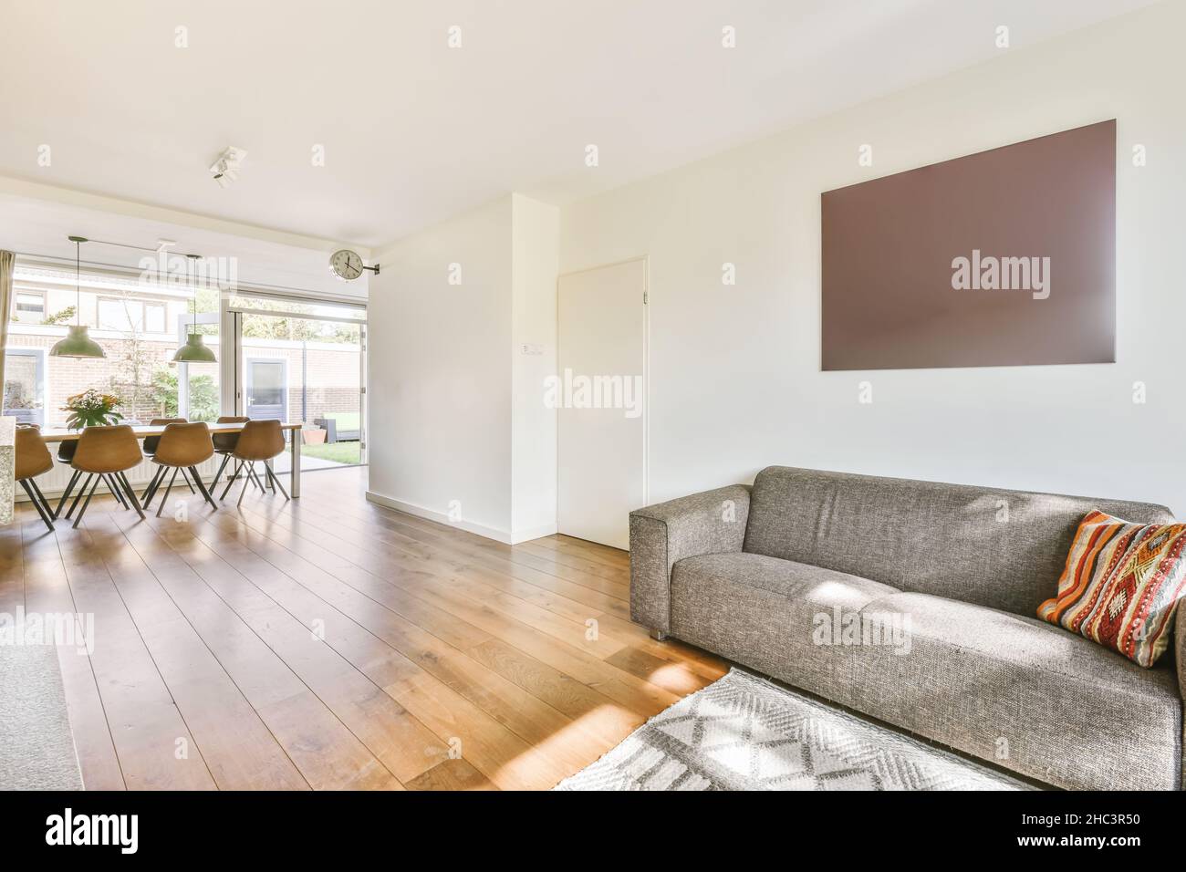Large gray sofa in a cozy living area with wooden floor Stock Photo - Alamy