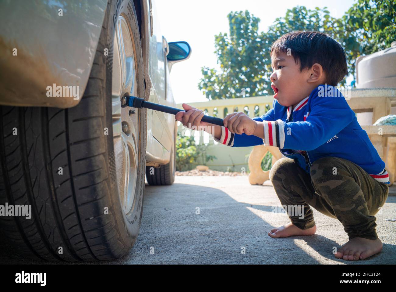 Little boy repairing car and changing wheel fixing a car Stock Photo ...