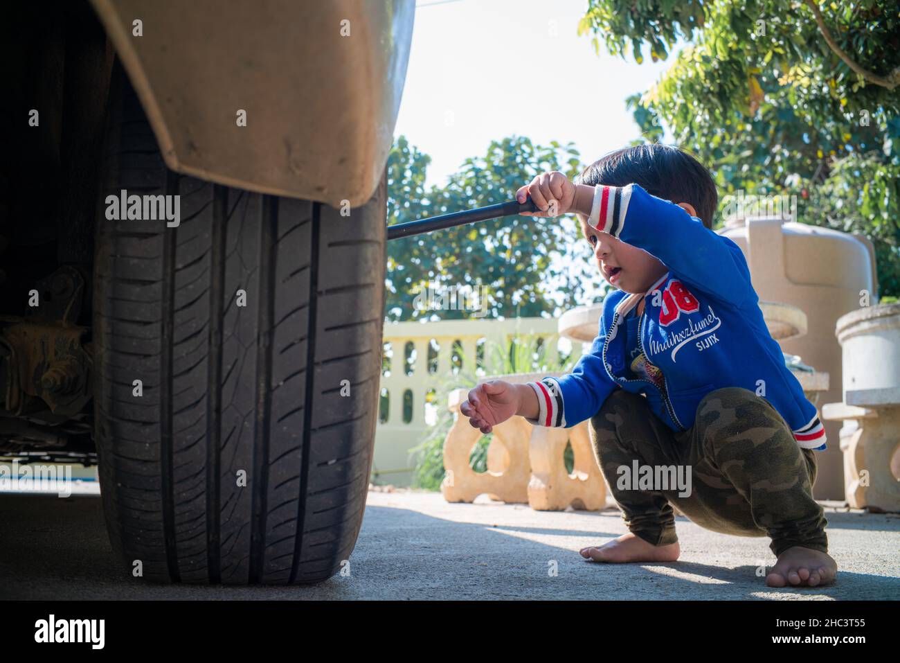 Little boy repairing car and changing wheel fixing a car Stock Photo ...