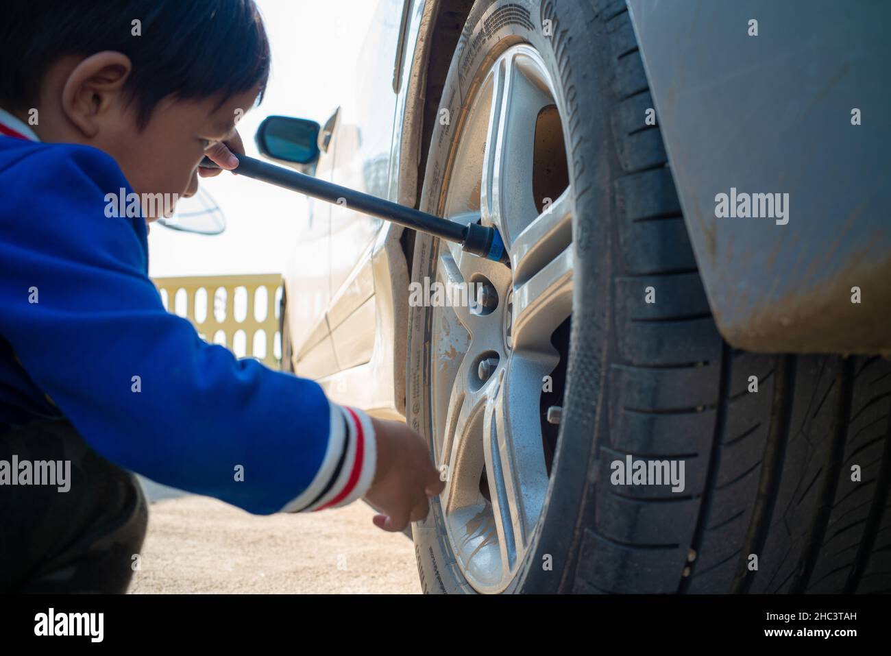 Little boy repairing car and changing wheel fixing a car Stock Photo ...