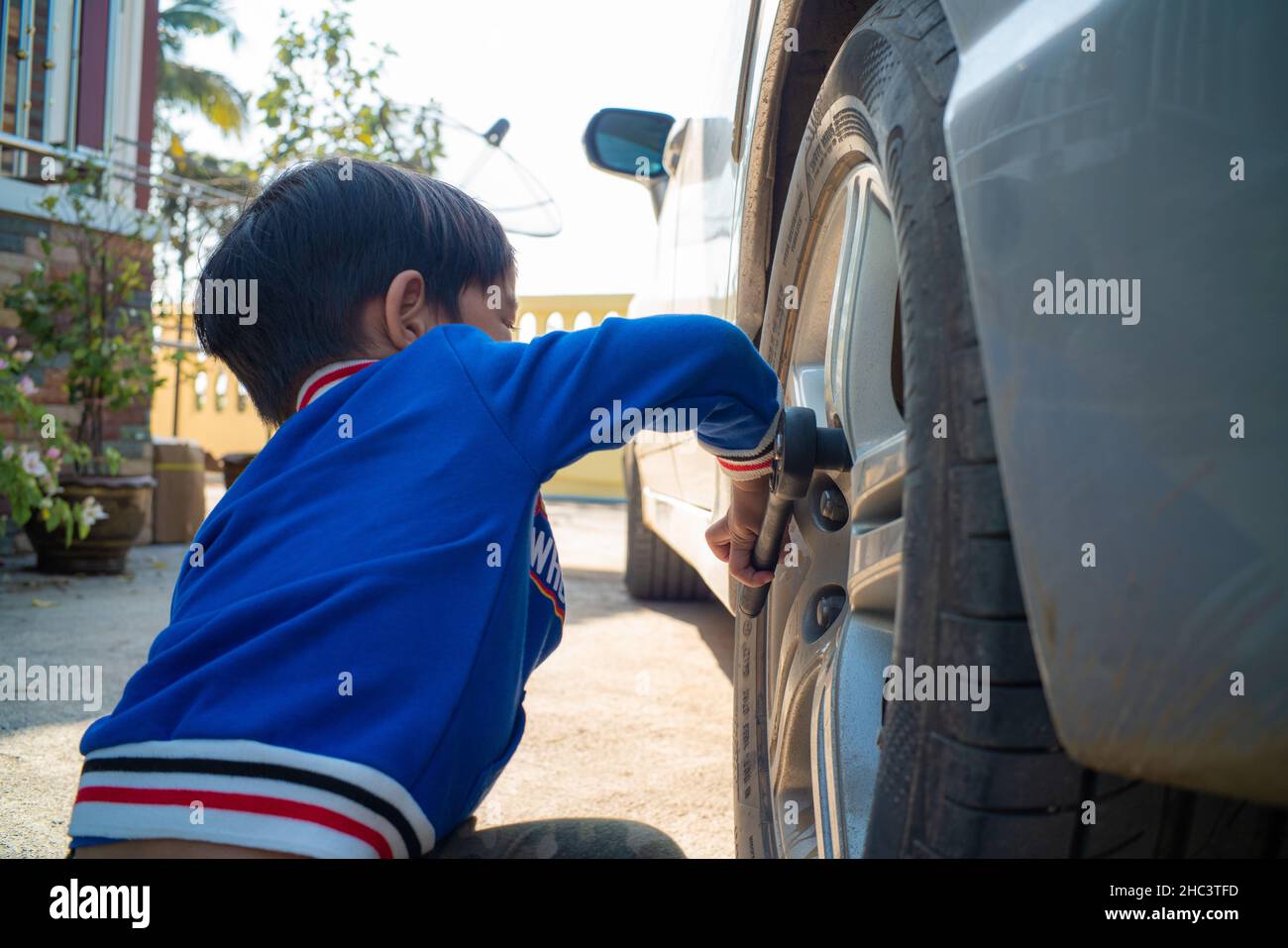 Little boy repairing car and changing wheel fixing a car Stock Photo ...