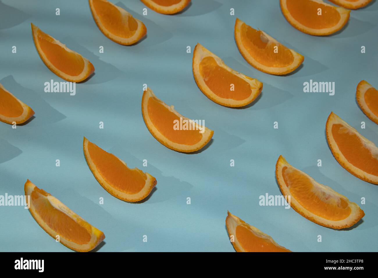 Colorful fruit pattern of fresh orange slices on light blue background ...