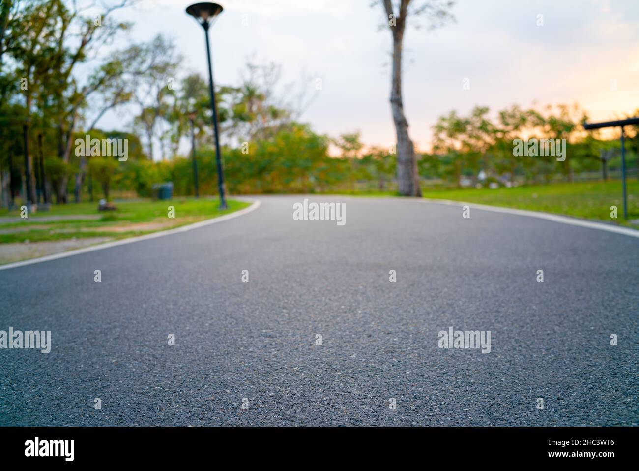 Empty asphalt pathway road in city park sunset running path Stock Photo ...