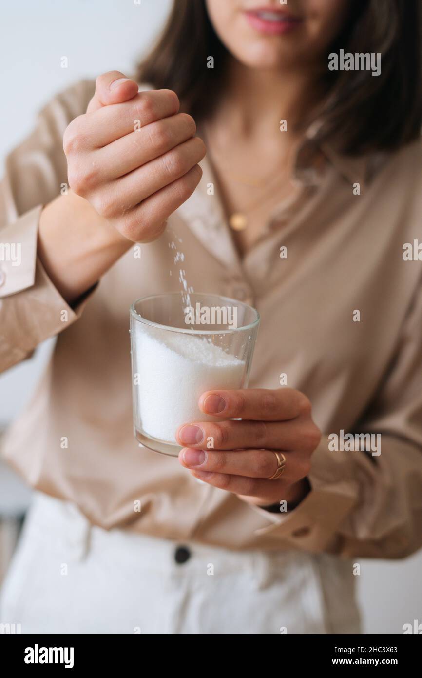 Vertical cropped shot of female artisan pouring dry mixture by hand ...