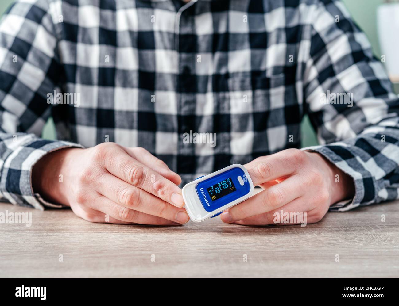 A man checking oxygen level at home with home oximeter, patient ...