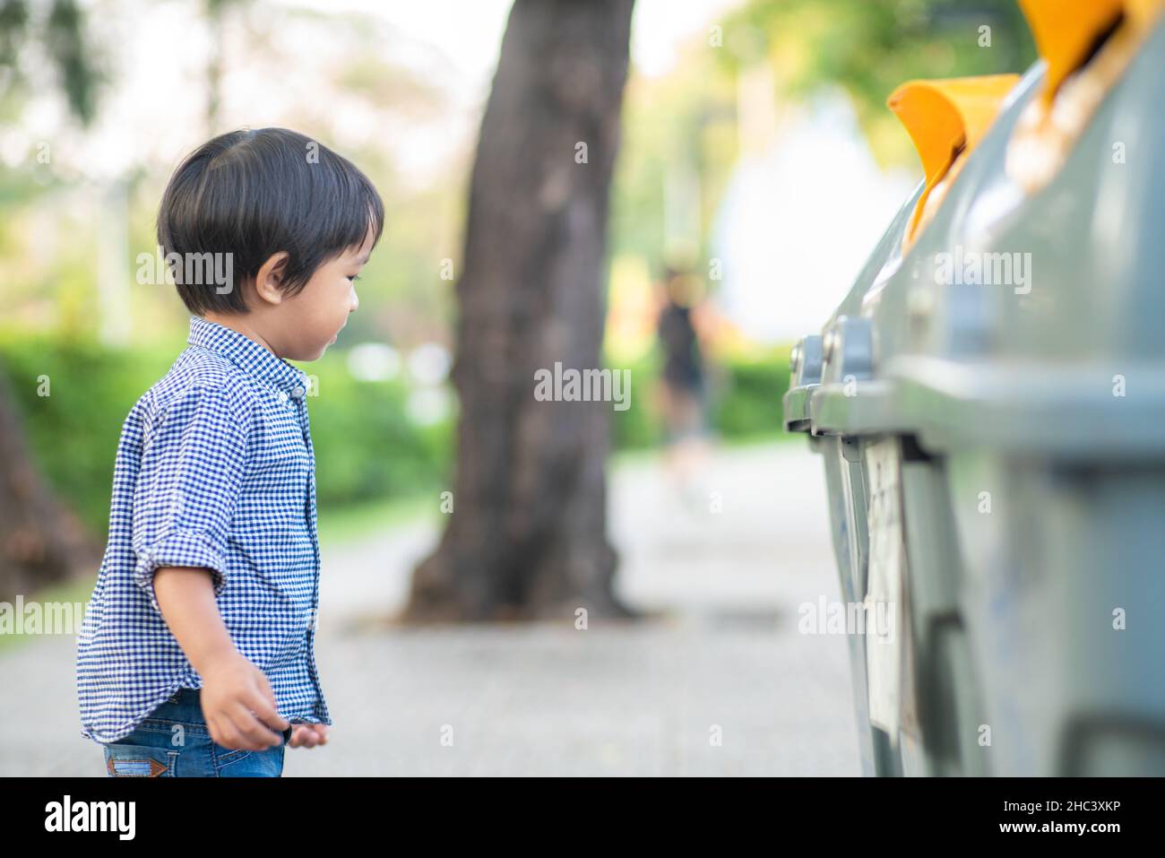 Adorable little boy keep garbage clean to bin in park eco environmennt ...