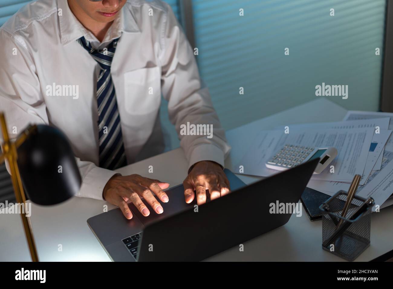 Overwork Concept The man sitting at his desk and focusing on working ...