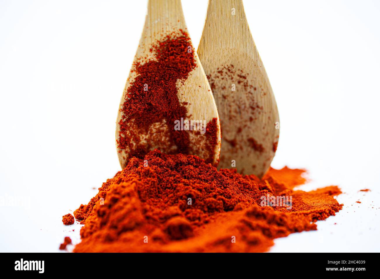 Closeup of the red pepper spice with wooden spoons isolated on white ...