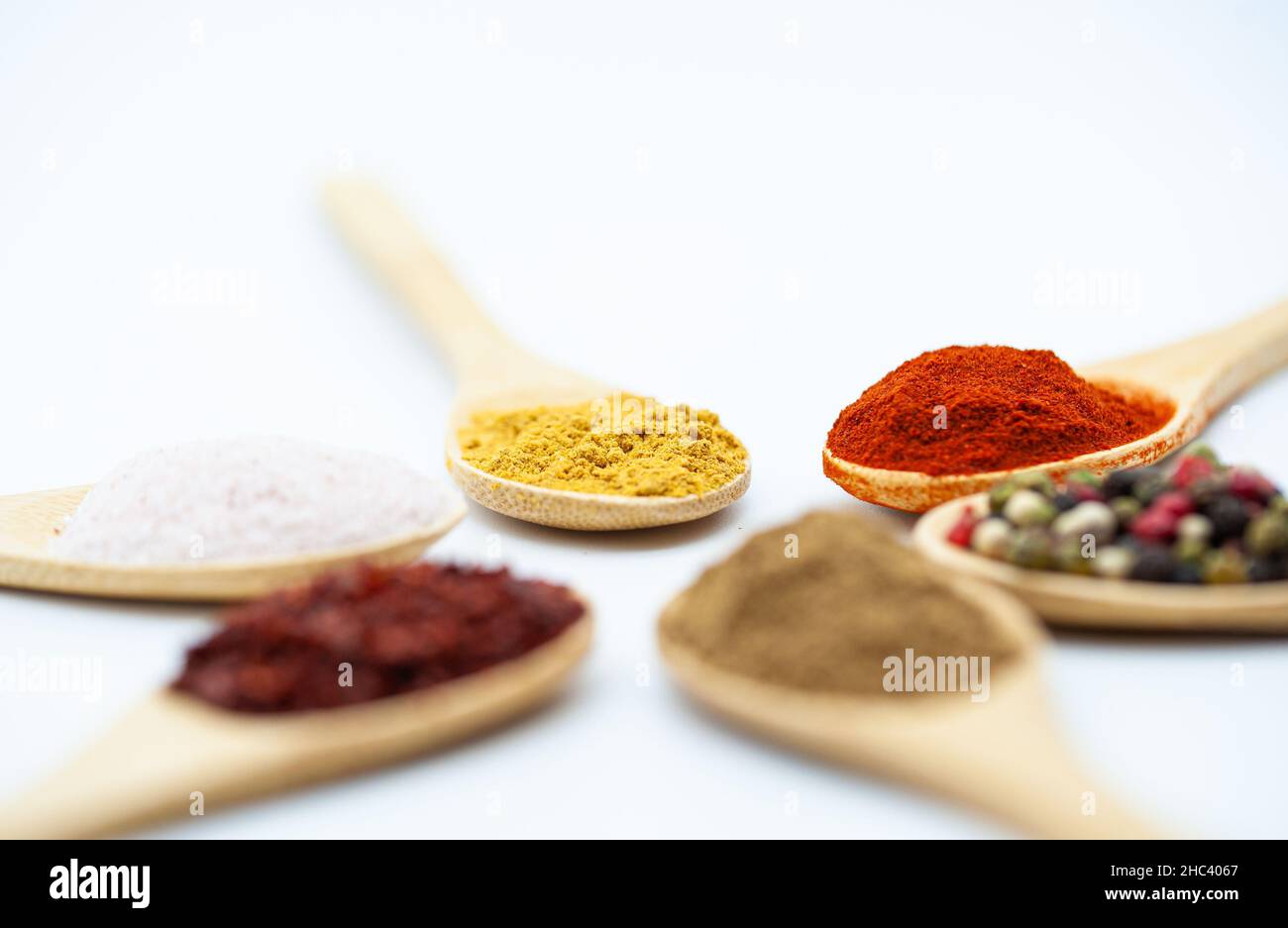 Closeup of the different types of spices with wooden spoons isolated on ...